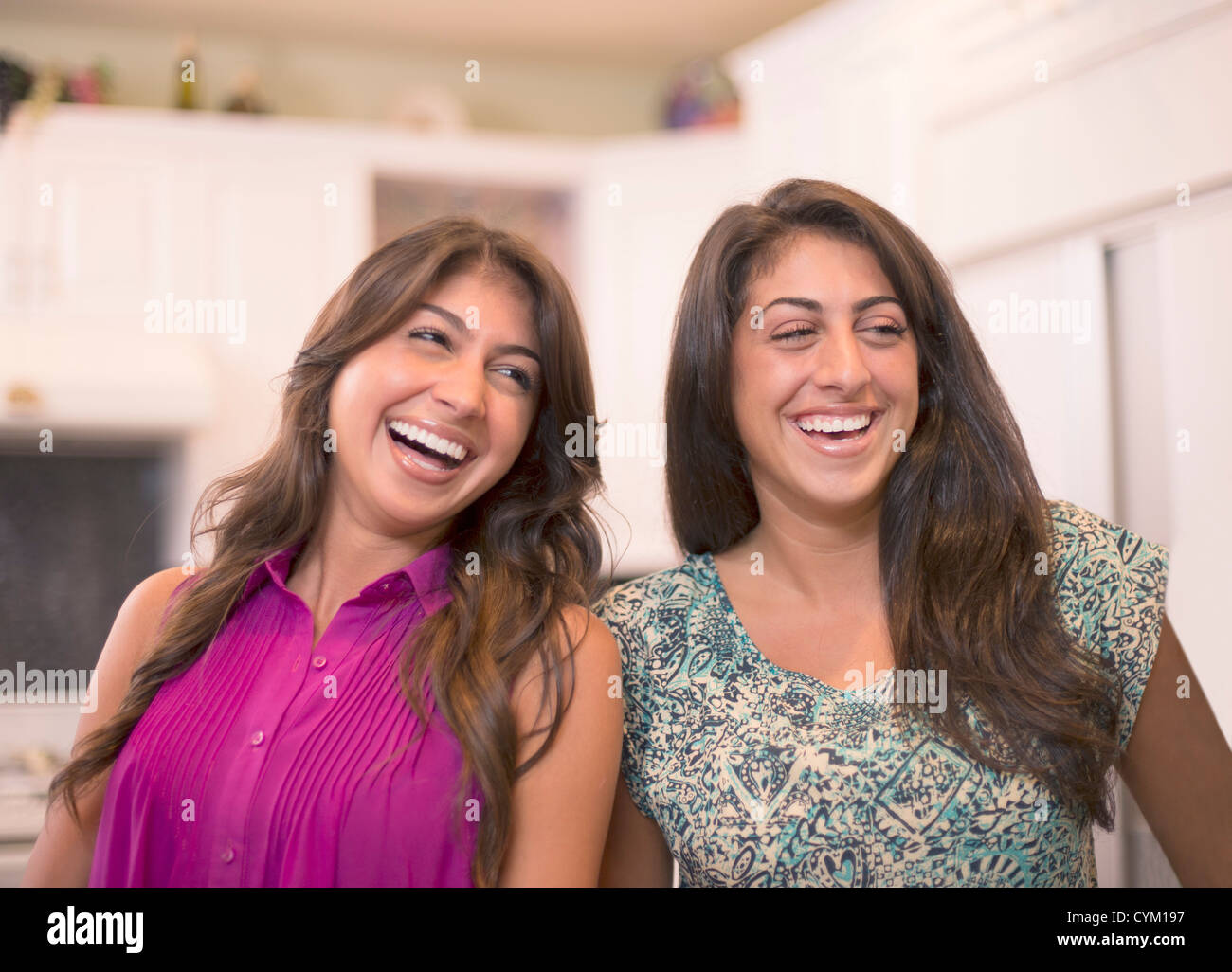 Sisters laughing together in kitchen Stock Photo - Alamy