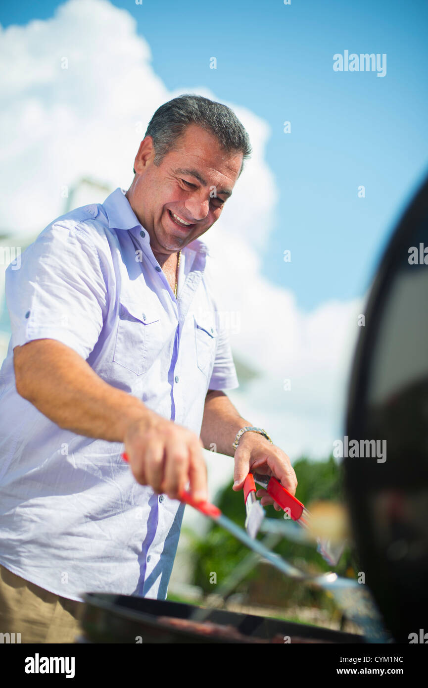 Smiling man grilling outdoors Stock Photo - Alamy