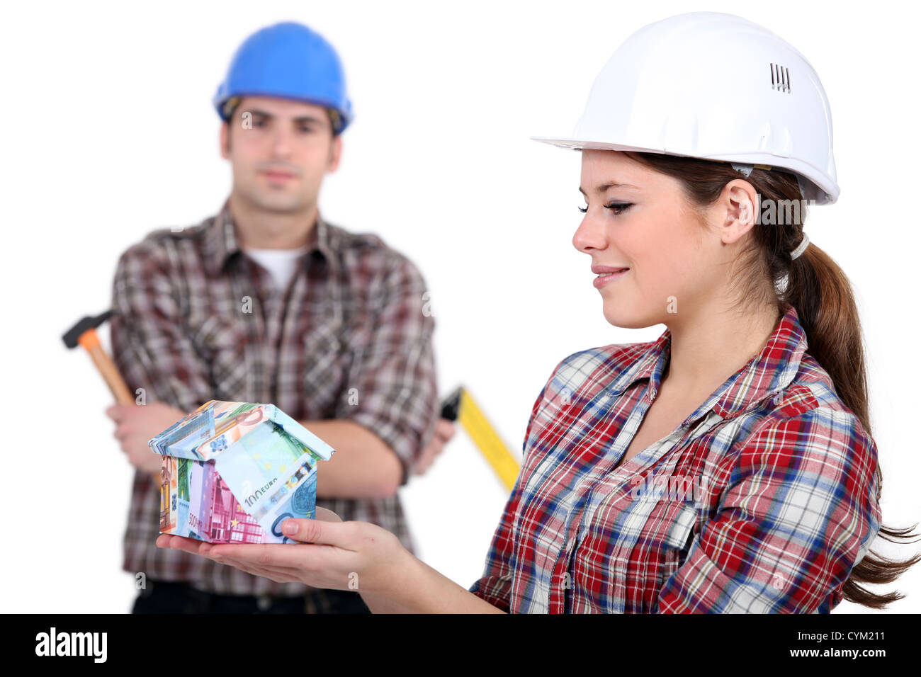 Female and male construction worker holding house made from money Stock ...