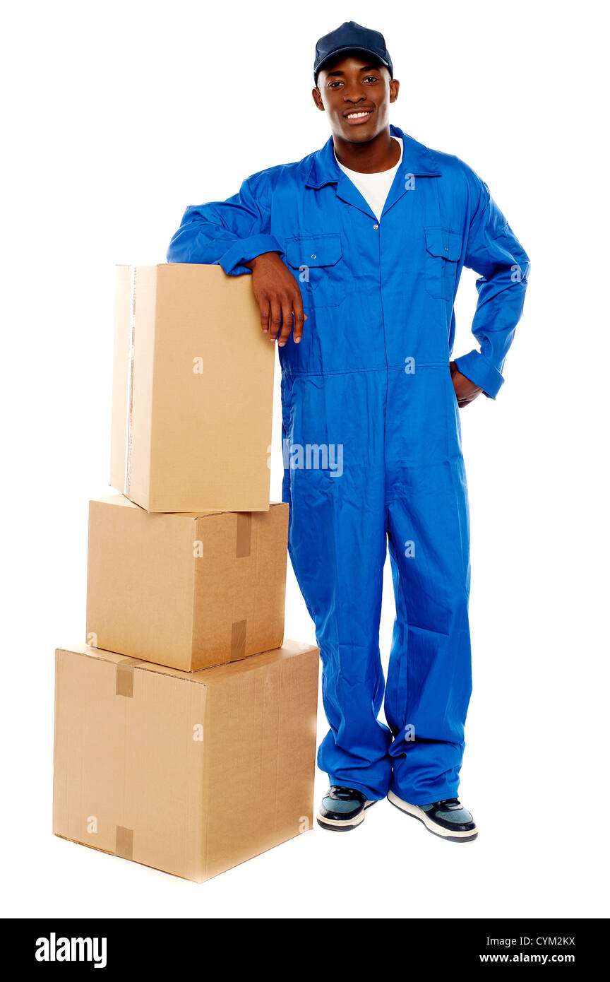 Courier boy standing beside boxes against white background, resting ...