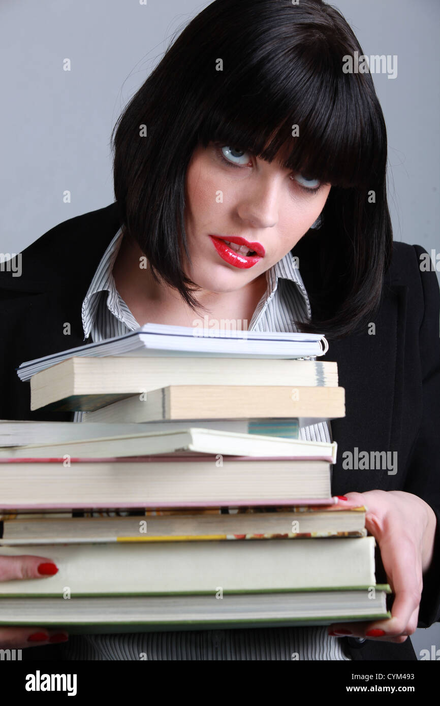 a woman holding a stack of books Stock Photo - Alamy