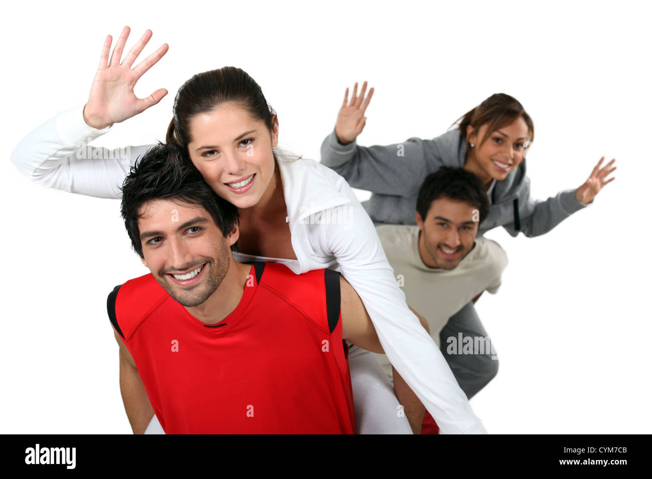 Two couple doing a piggy back ride race Stock Photo - Alamy
