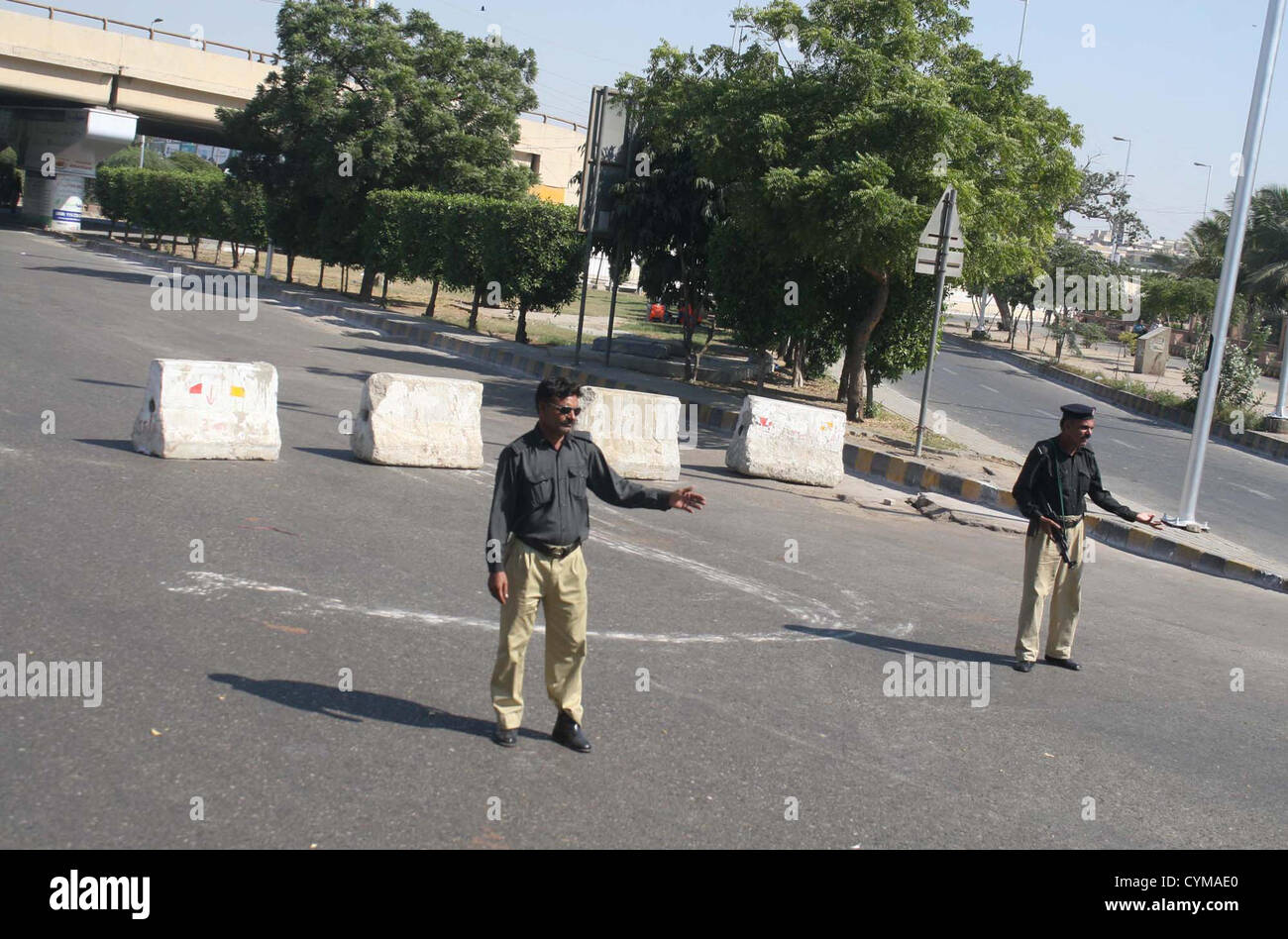 Police officials stand guard at a closed road that leads towards ...