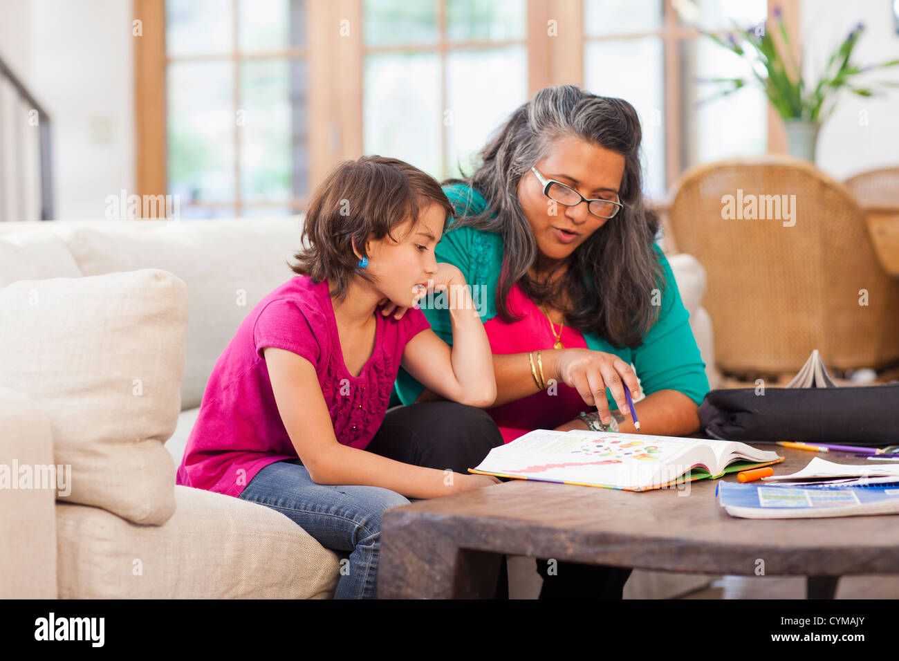 Mother helping daughter with homework Stock Photo - Alamy