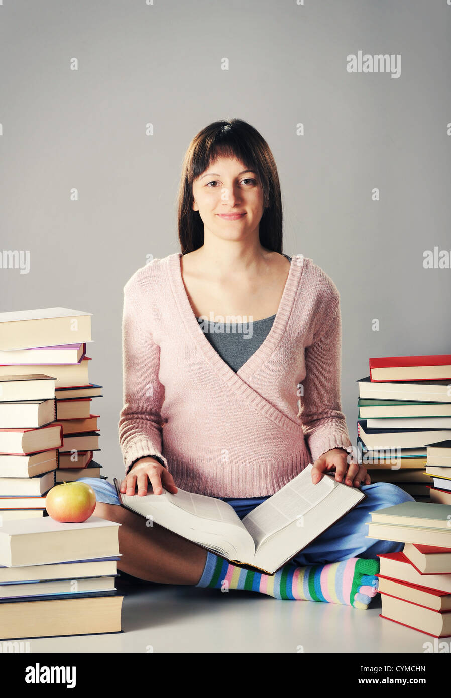 Cute girl studying with a big stack of books Stock Photo - Alamy