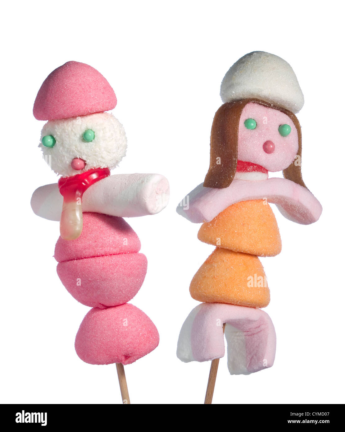 A male and a female figurine made out of candies on a stick over a ...