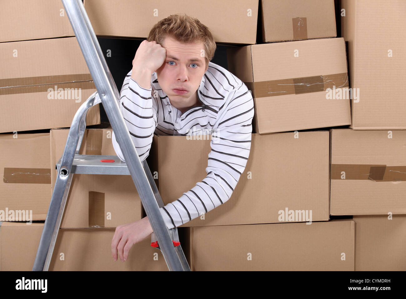 Man stuck behind stacks of cardboard boxes Stock Photo - Alamy