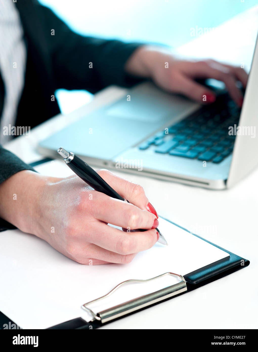 Closeup of woman copying data from laptop to notepad, Making important ...