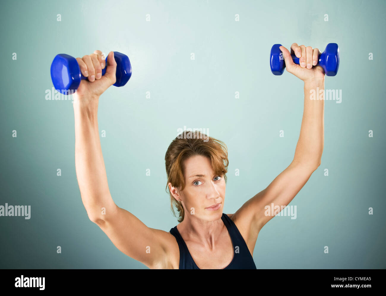 Pretty athletic woman working out with dumbbells Stock Photo - Alamy