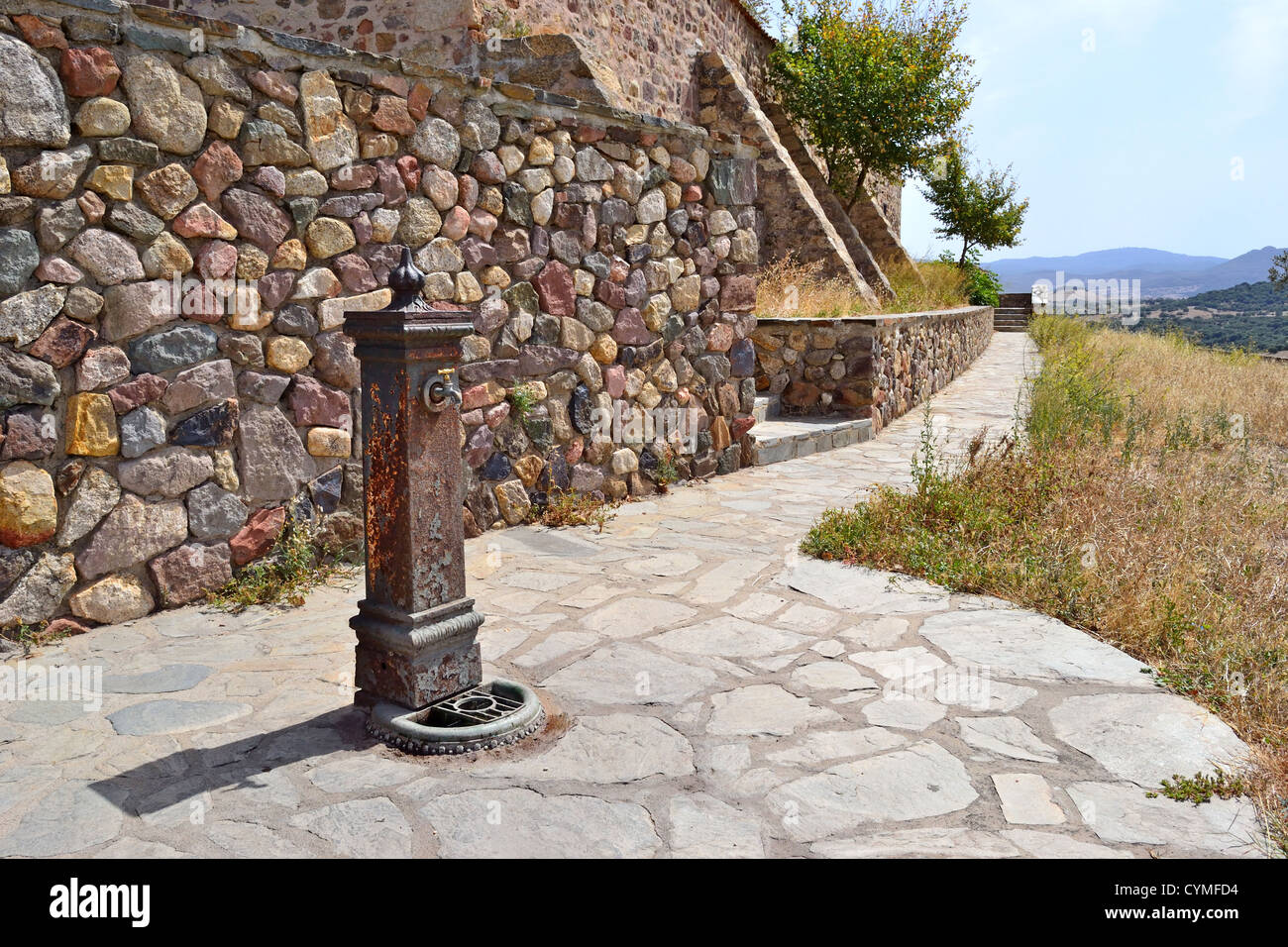 rusty fountain in front of a stone wall Stock Photo - Alamy