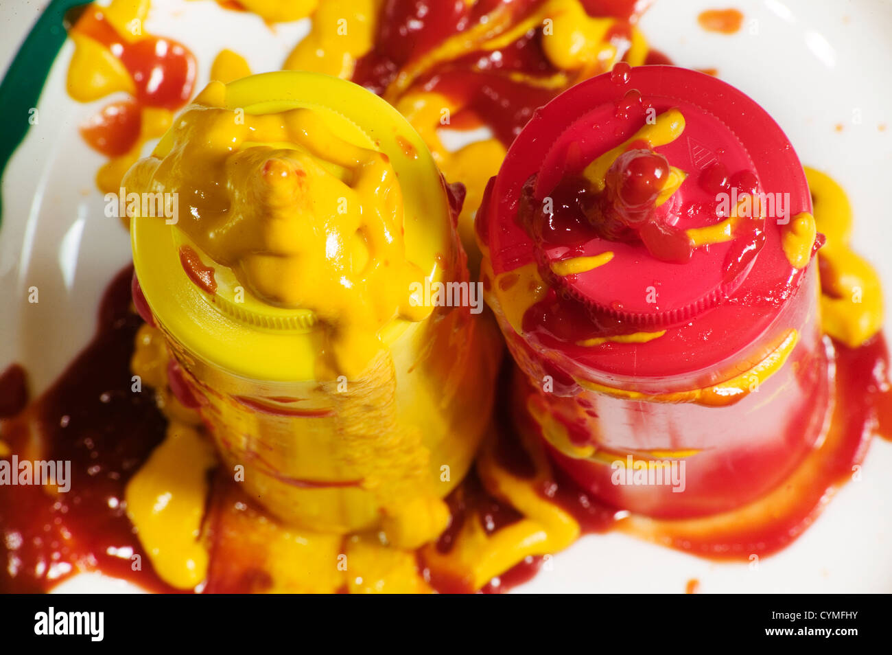 Messy mustard and ketchup squeeze bottles standing up on a plate Stock ...
