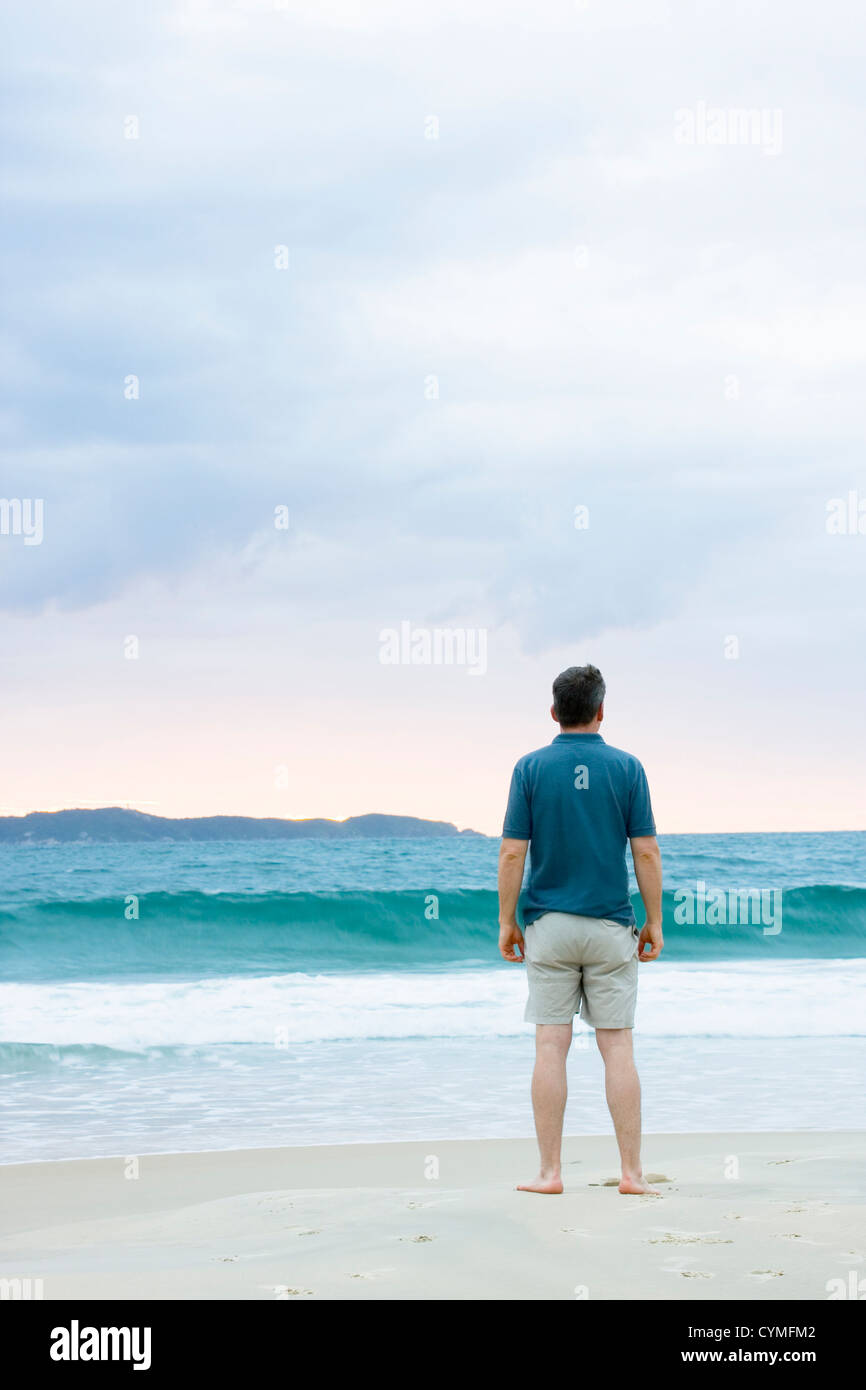 Man standing on the beach contemplating the sea Stock Photo - Alamy