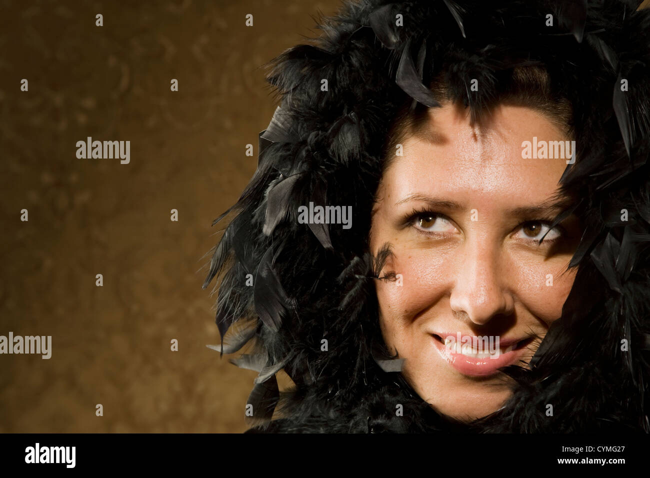 Pretty Hispanic Woman Wearing a Feather Boa in front of Gold Wallpaper ...
