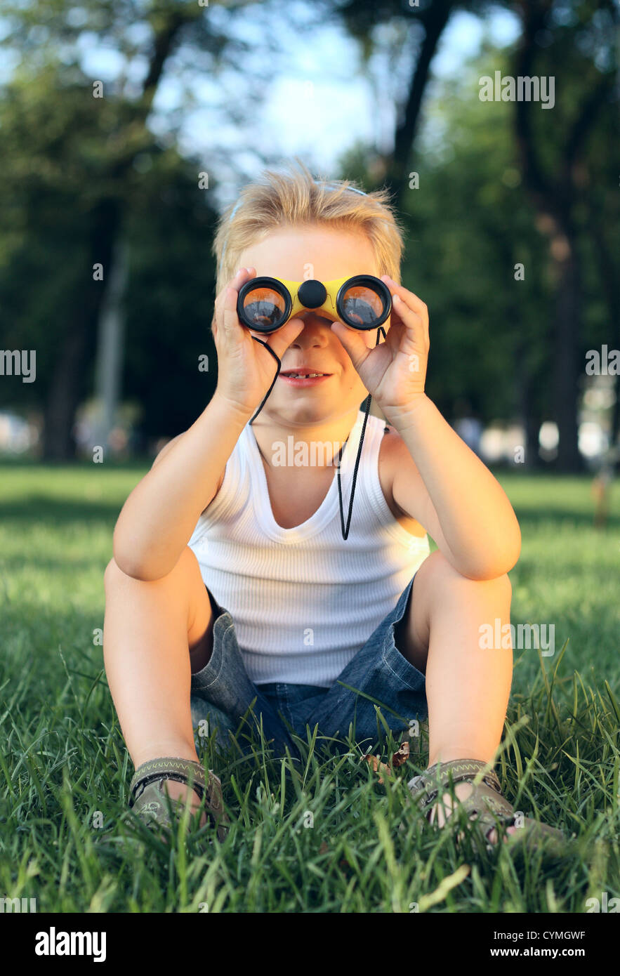 Little boy looking through the binoculars in th park Stock Photo - Alamy