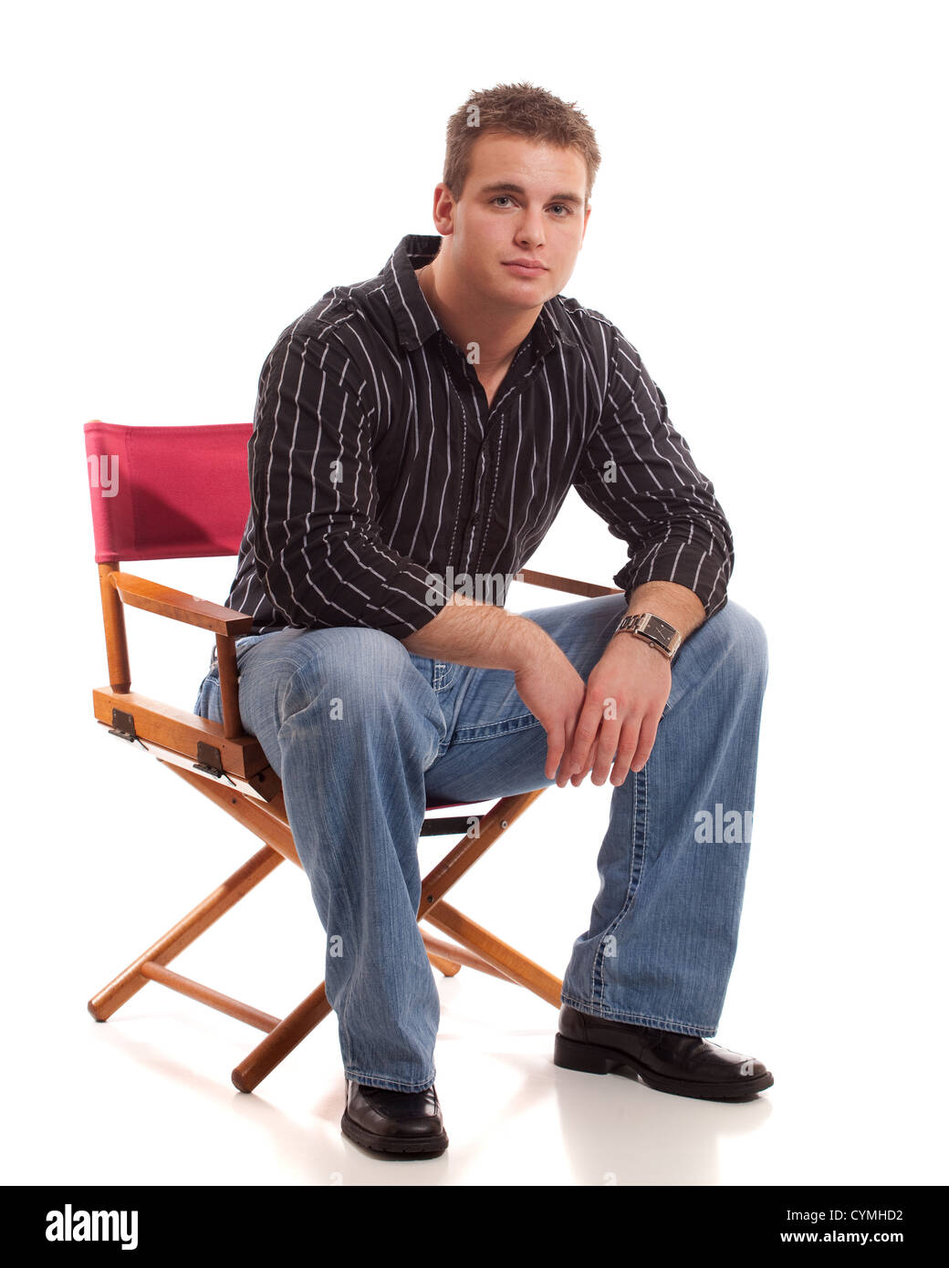 Casual young man seated in directors chair Stock Photo - Alamy