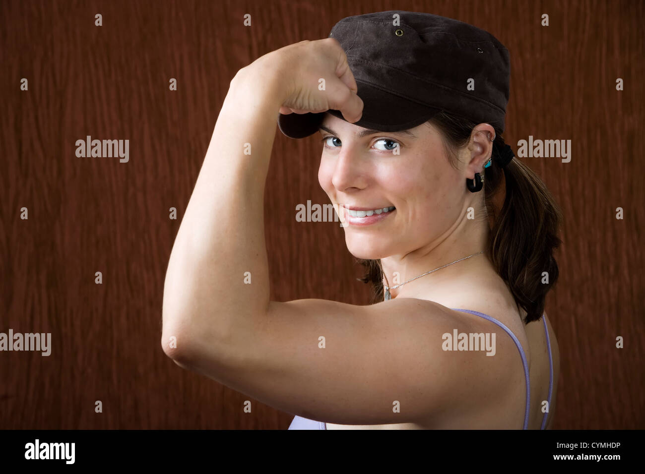 Closeup of woman with blue eyes wearing a cap flexing her bicep Stock ...