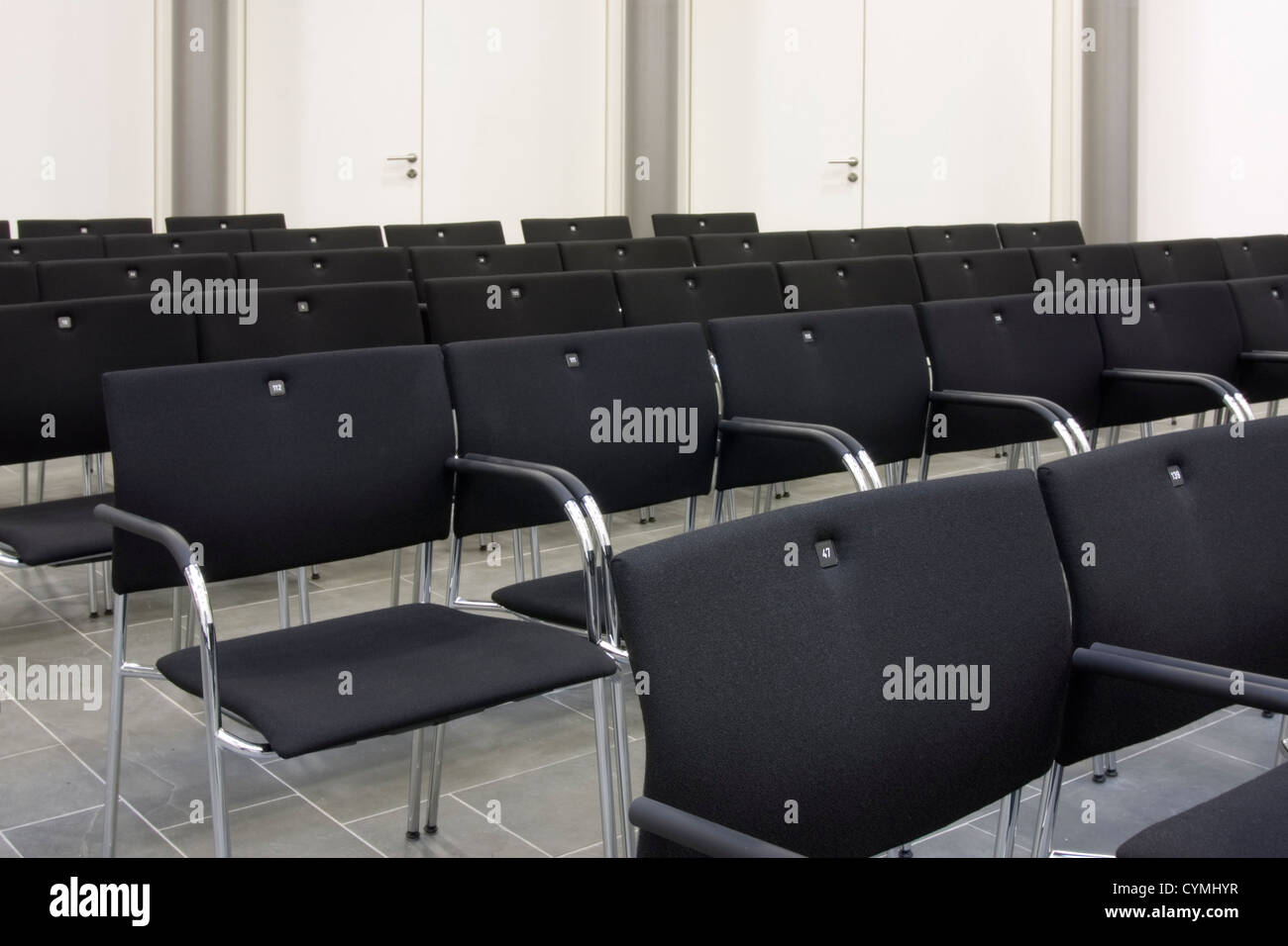 Black chairs of a lecture hall in a row Stock Photo - Alamy