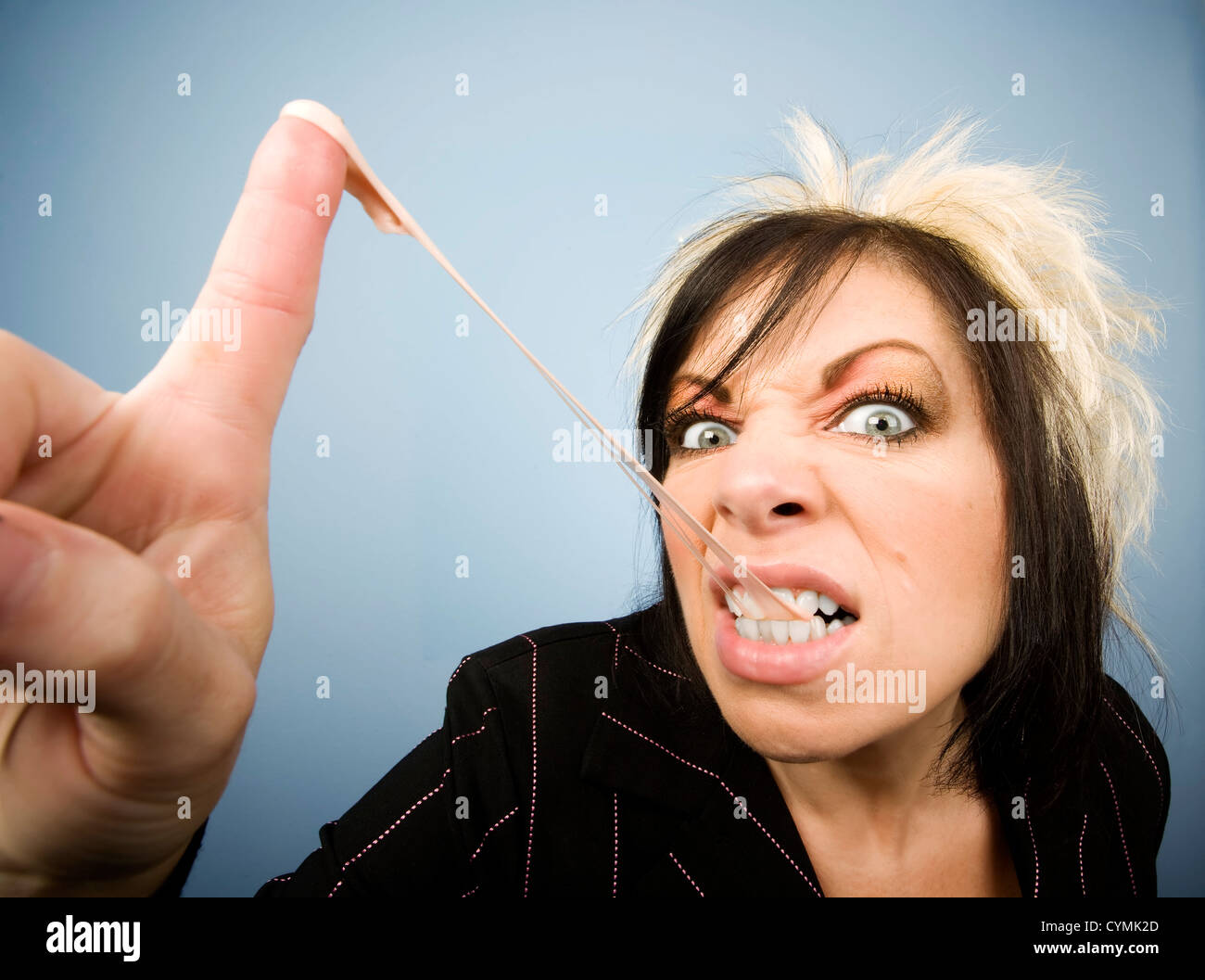 Portrait of a creative businesswoman stretching gum, on her fingertip ...