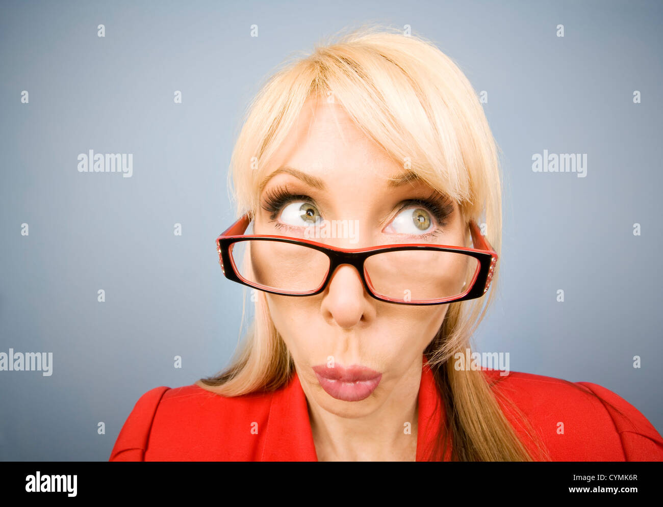 Woman in red pursing her lips and making a funny face Stock Photo - Alamy