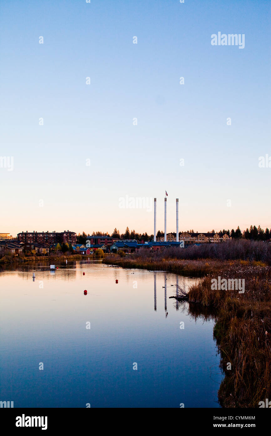 Three pipes stand tall over a body of water on a sunny evening in Bend ...