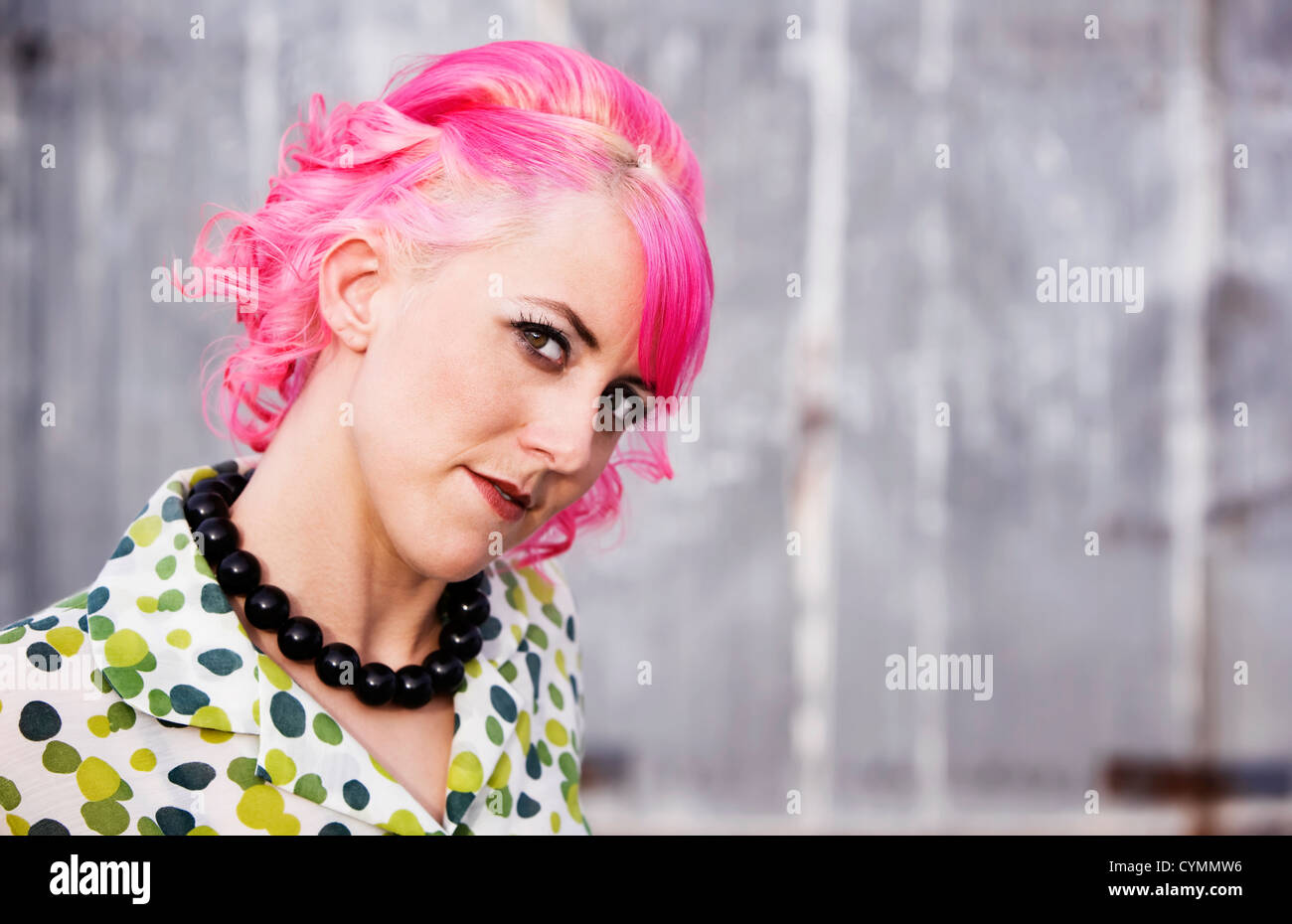 Woman with pink hair in an alley Stock Photo - Alamy