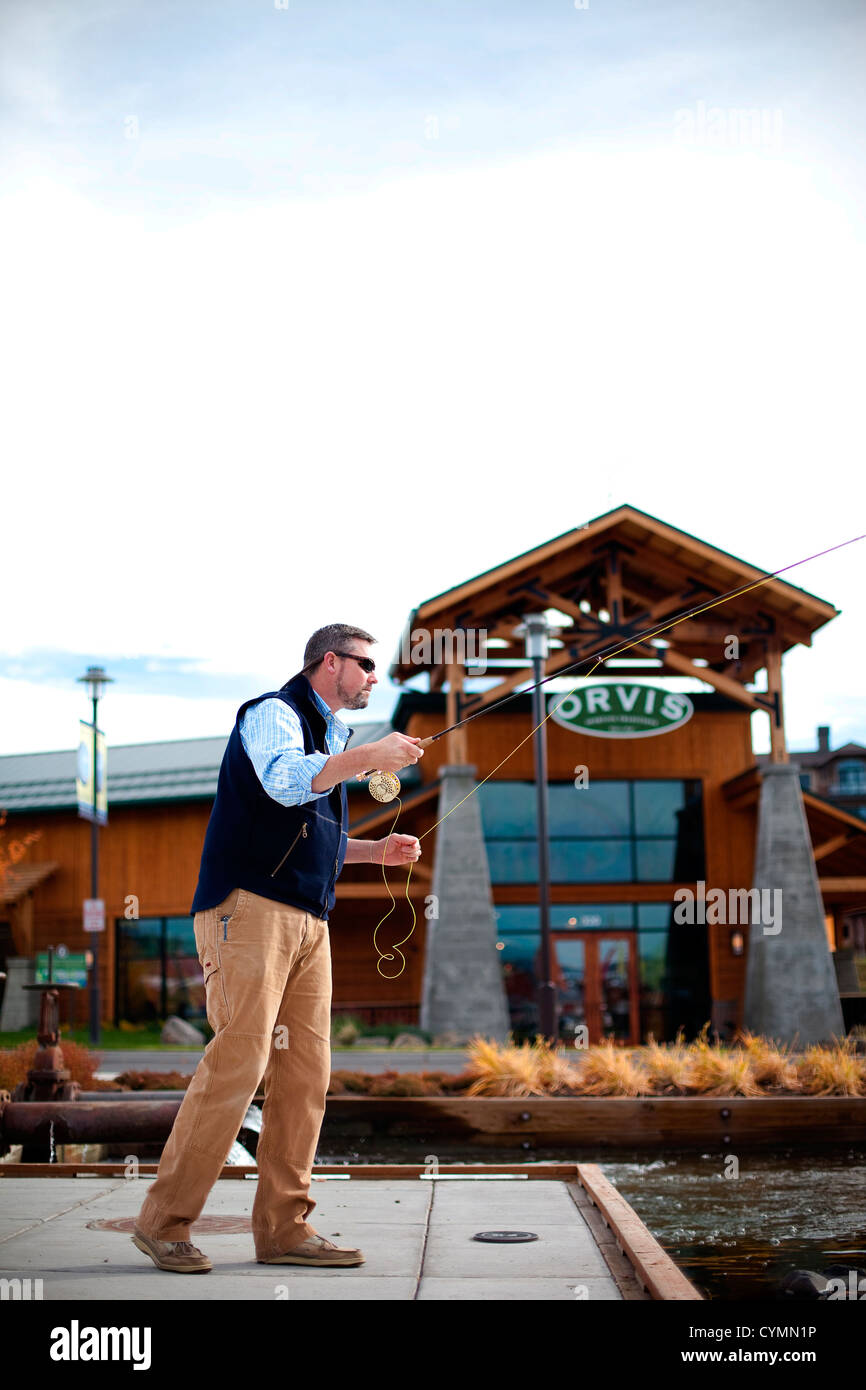 A man practices his fly fishing outside the Orvis store in Bend, Oregon ...