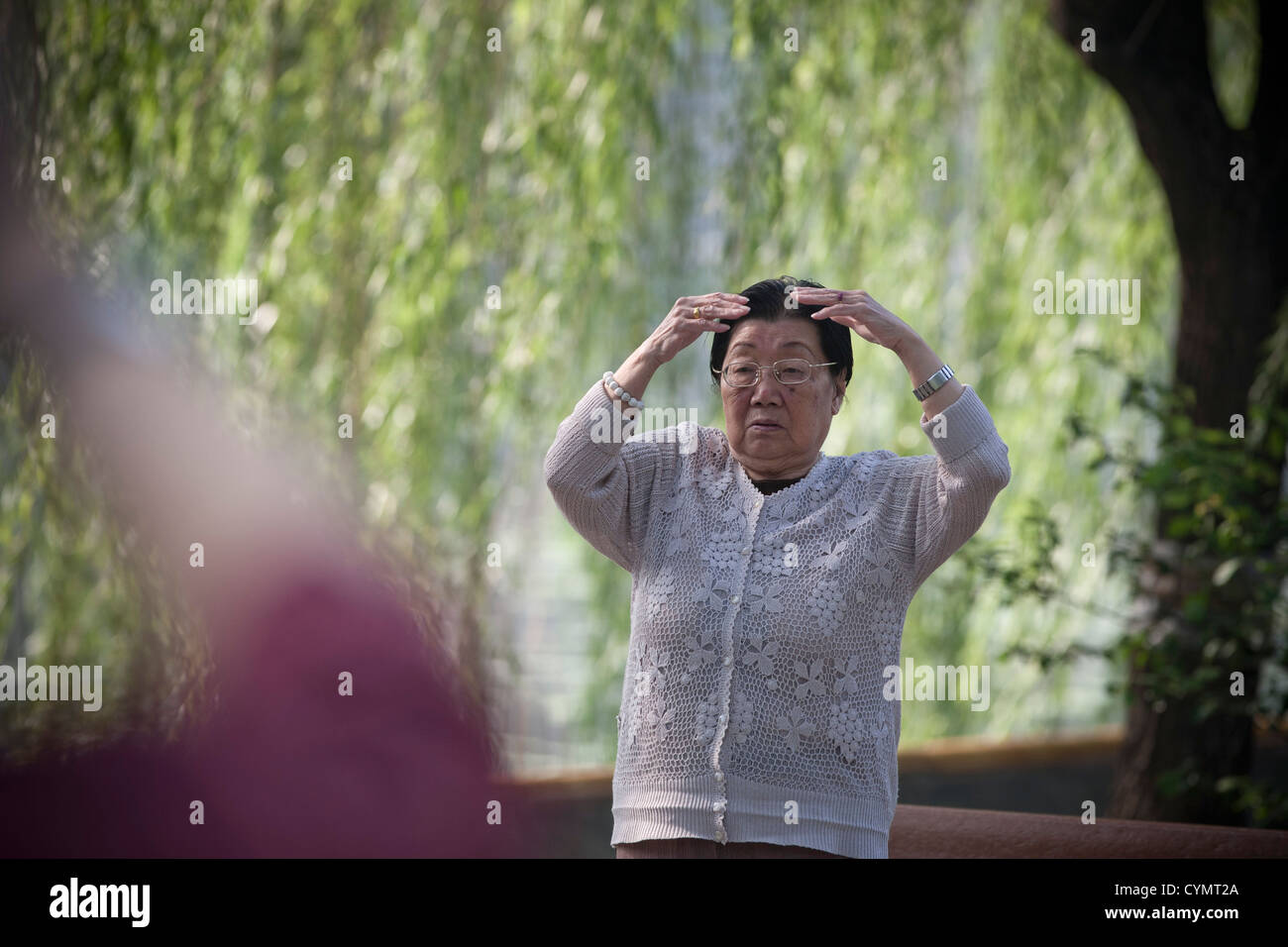 A woman taking part in morning exercises in Beihai Park, Beijing, China ...
