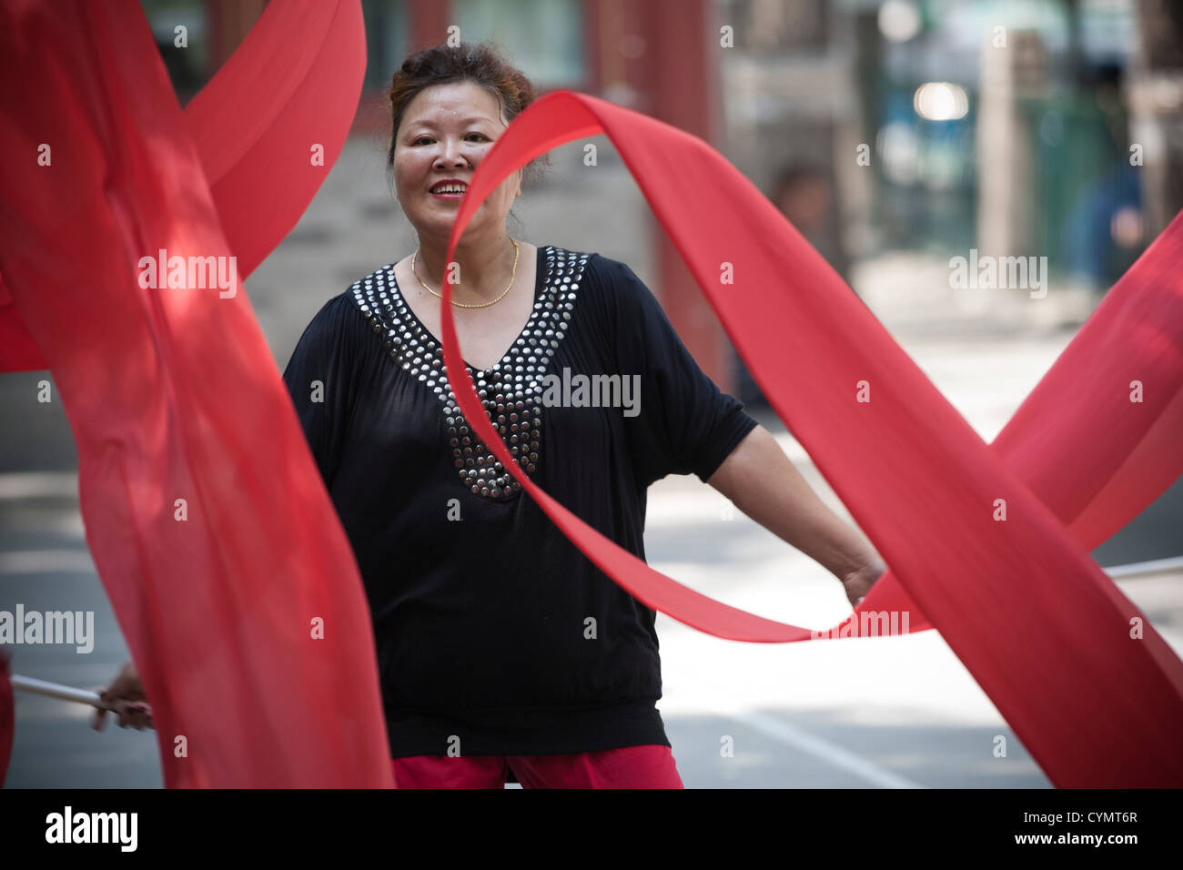 A woman with a long ribbon taking part in morning exercises in Beihai ...