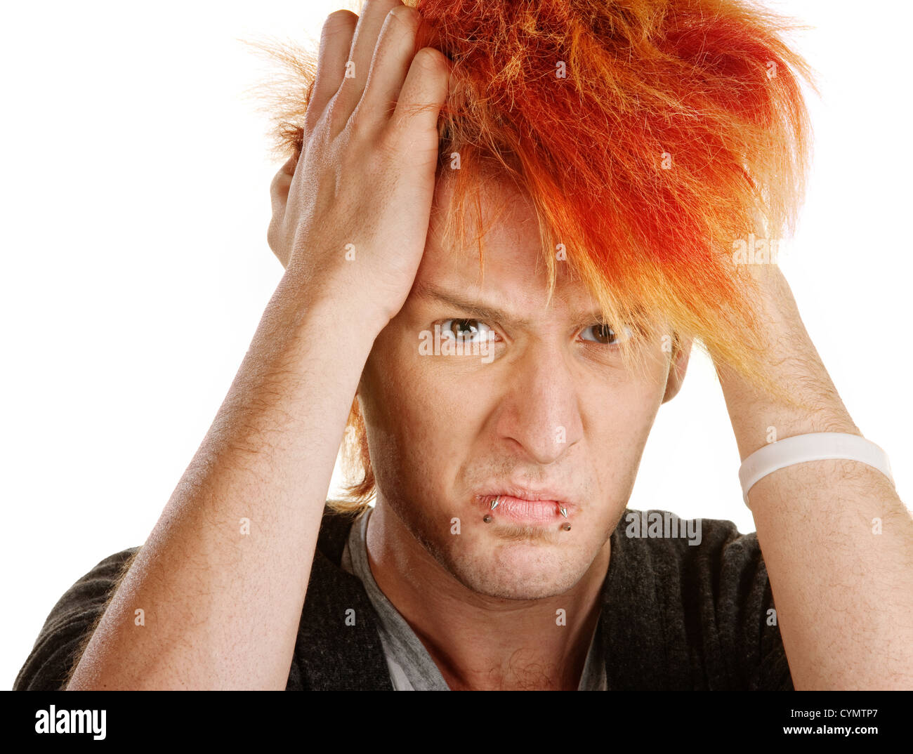 Angry young man pulling his orange hair Stock Photo - Alamy