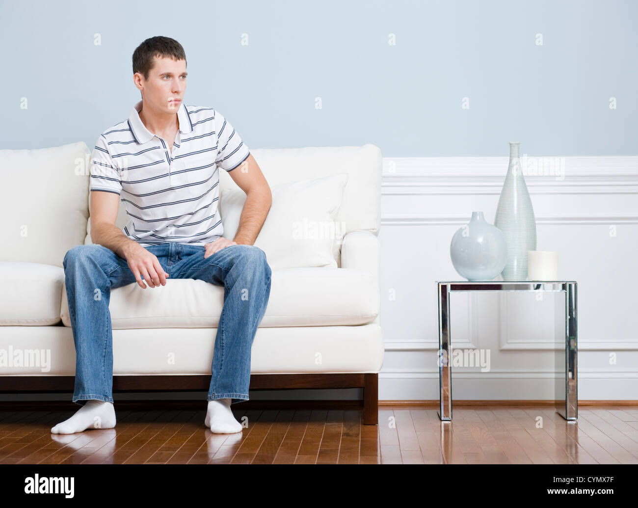 Man Sitting on Living Room Couch Stock Photo - Alamy