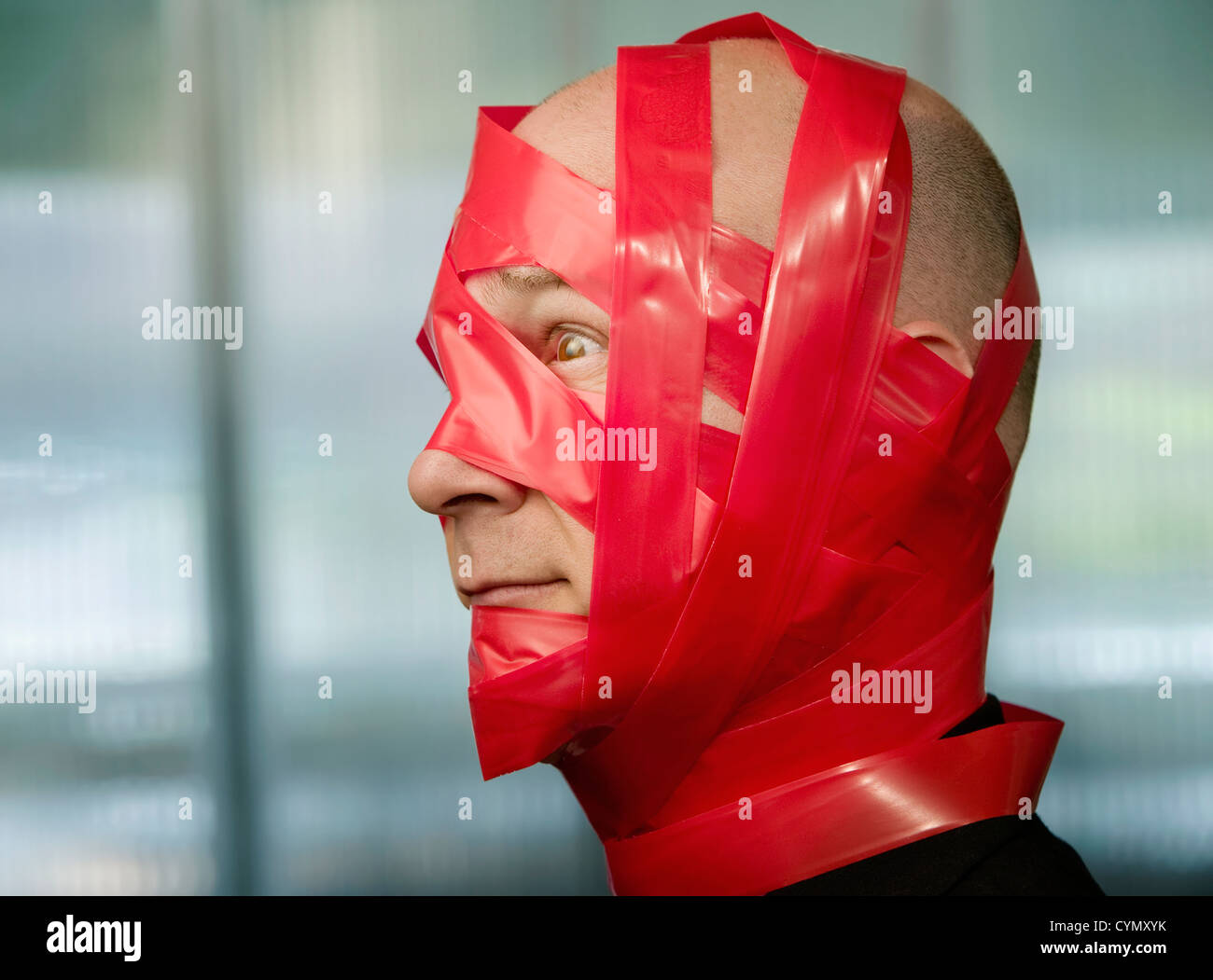 Businessman wrapped in red tape Stock Photo - Alamy