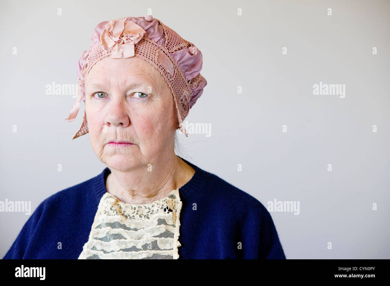 Dour senior woman in the studio wearing a vintage hat and lace Stock ...