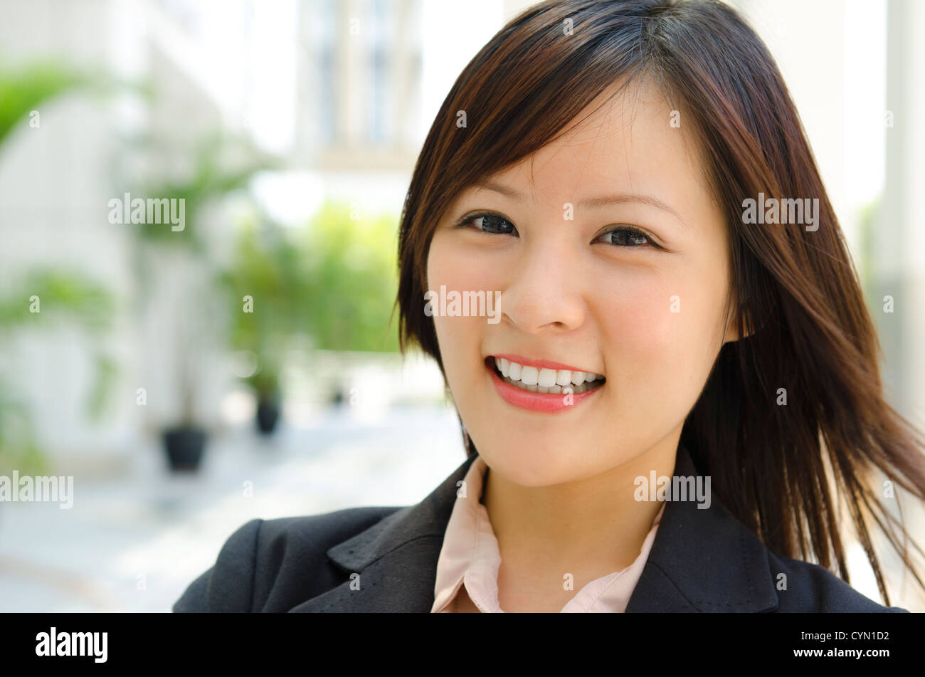 Asian female with her cheerful smile, outside modern building Stock ...