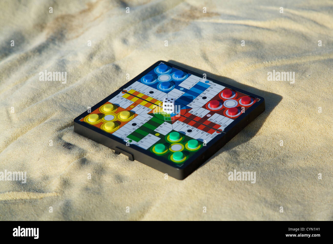 Parcheesi prepared on a yellow towel at the beach Stock Photo - Alamy