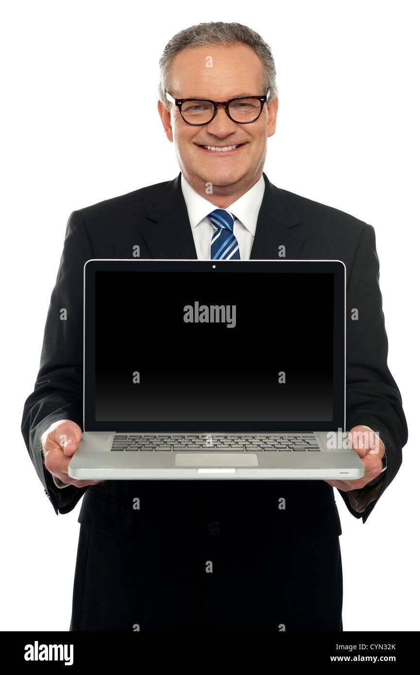Senior executive standing with open laptop isolated against white ...