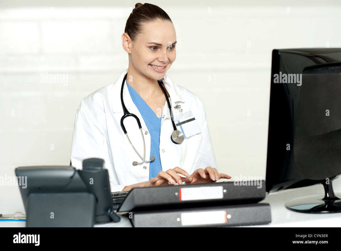 Medical professional working on computer looking at lcd screen while ...