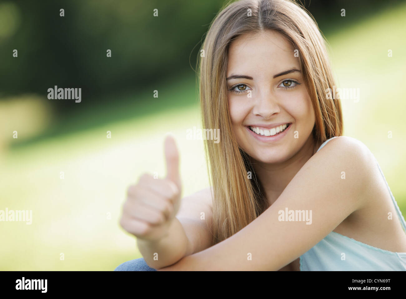 Beautiful young woman showing thumb up sign Stock Photo - Alamy
