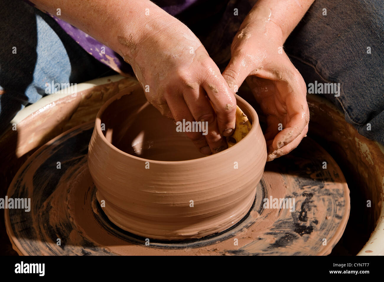 Shaping a new clay pot on a pottery wheel Stock Photo - Alamy