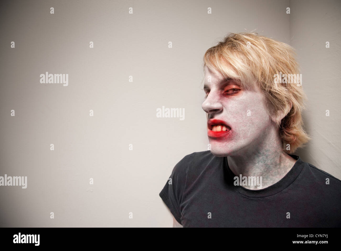 Portrait of sneering zombie syanding in corner Stock Photo - Alamy