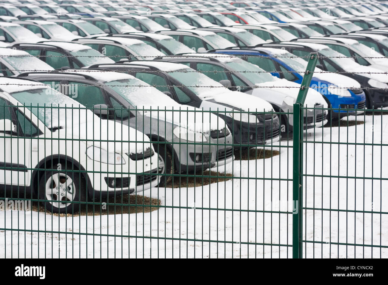Stocked cars covered with snow behind a barb wired fence Stock Photo ...