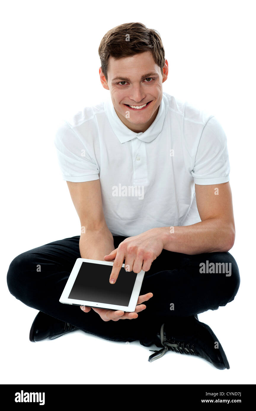 Seated guy with finger on touch pad device smiling at camera Stock ...