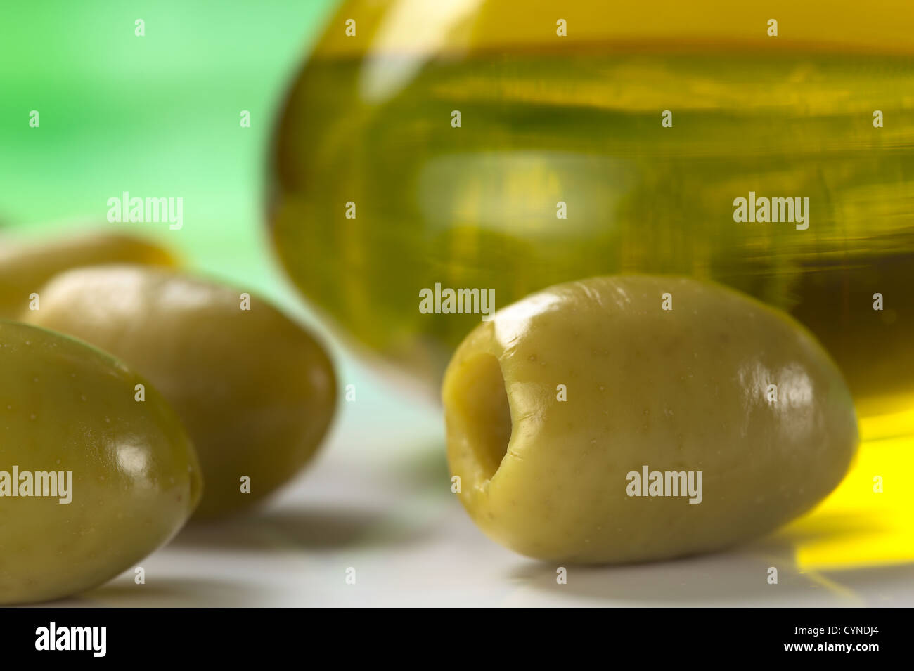 Green olive with olive oil in the back (Very Shallow Depth of Field ...
