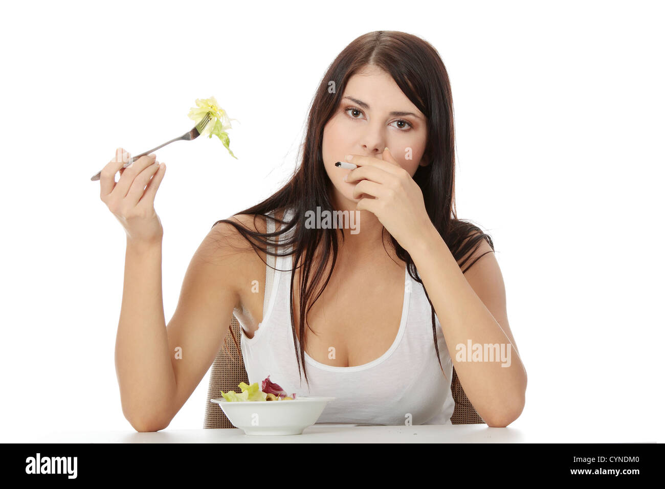 Girl eating salad and smoking sigarette. Unhealthy life concept Stock ...