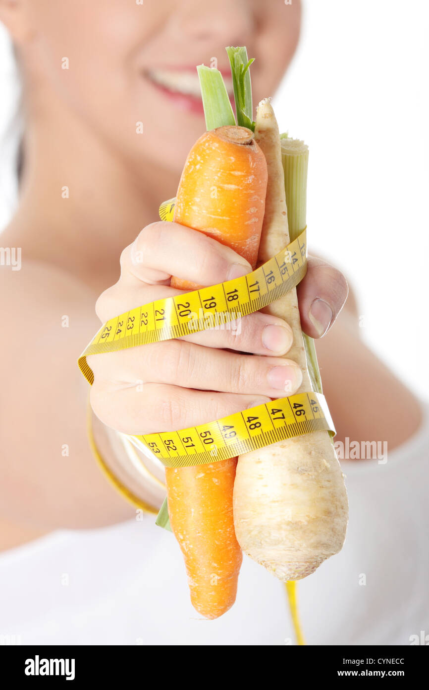 Woman's hand holding vegetables and measuring tape, isolated on white ...