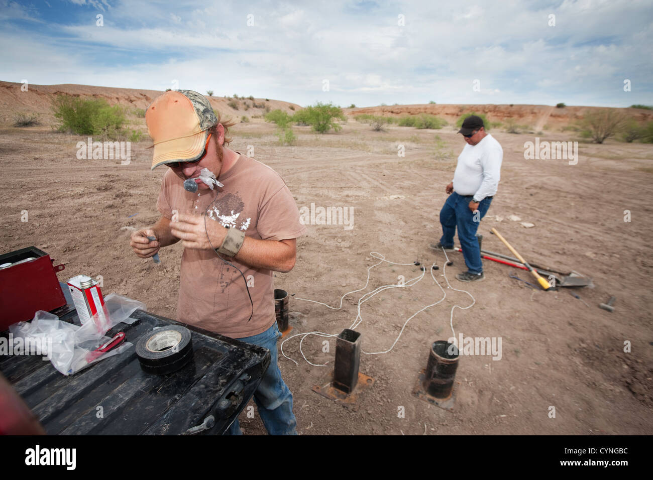 Special effect team setting up pyrotechnics outdoors in desert Stock ...