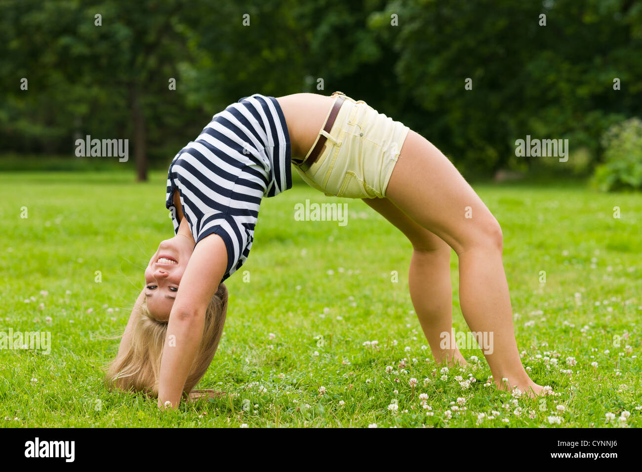 Young smiling girl doing bridge at the park Stock Photo - Alamy