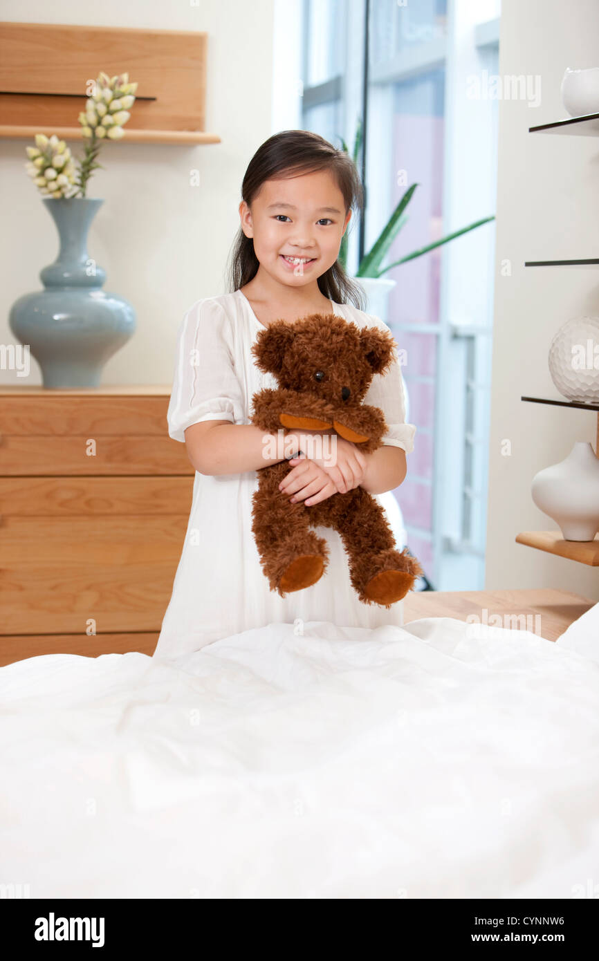 Little girl in bedroom with teddy bear in hand Stock Photo - Alamy