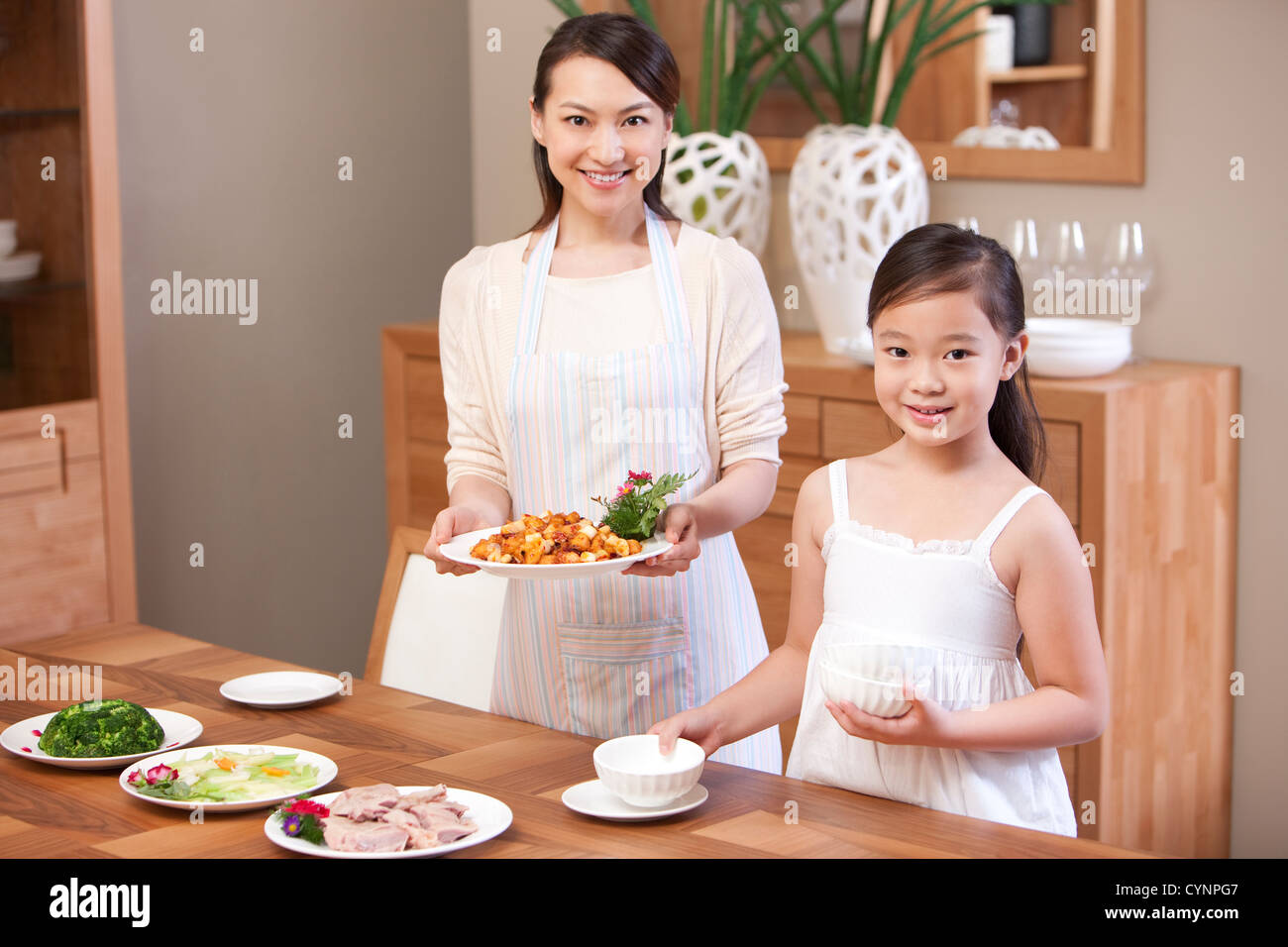 Mother and daughter setting the table Stock Photo - Alamy