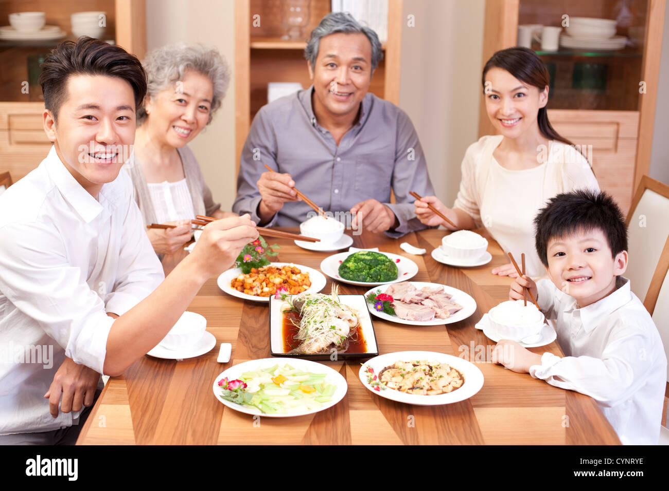 Happy family enjoying meal time Stock Photo - Alamy