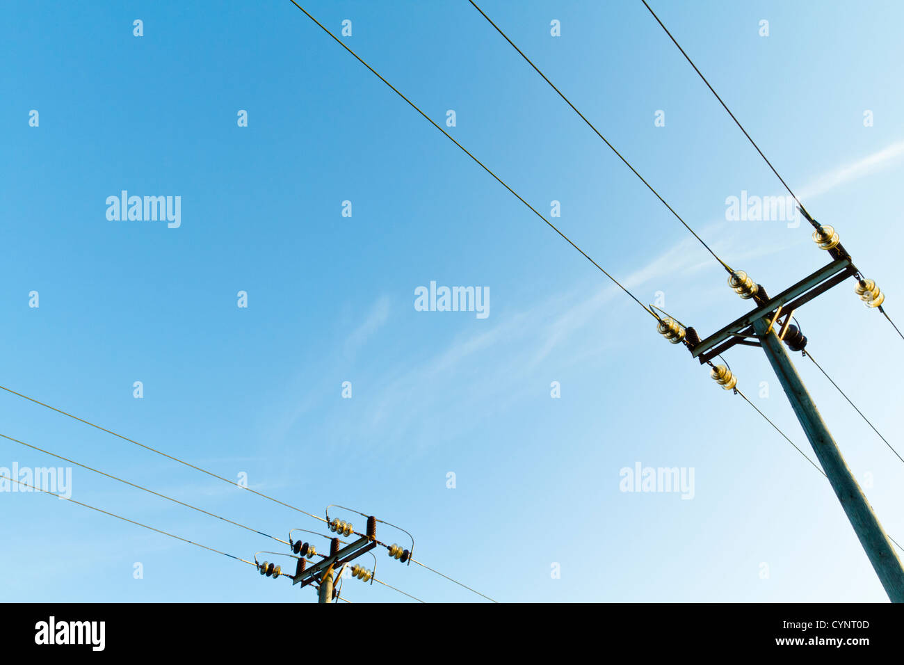 Electricity utility poles with overhead power lines against a blue sky ...